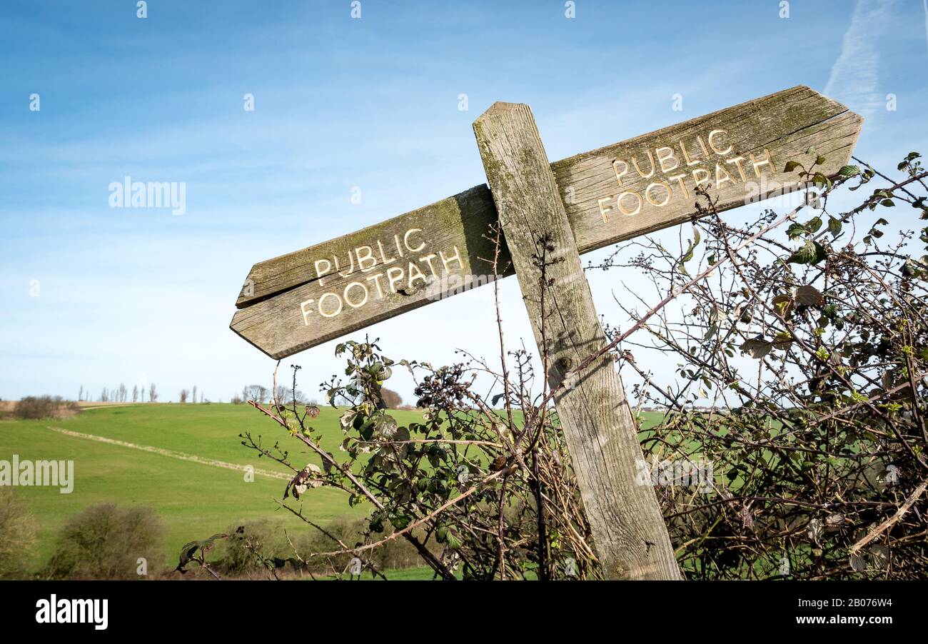 English countryside public footpath sign. A crooked sign covered in ...