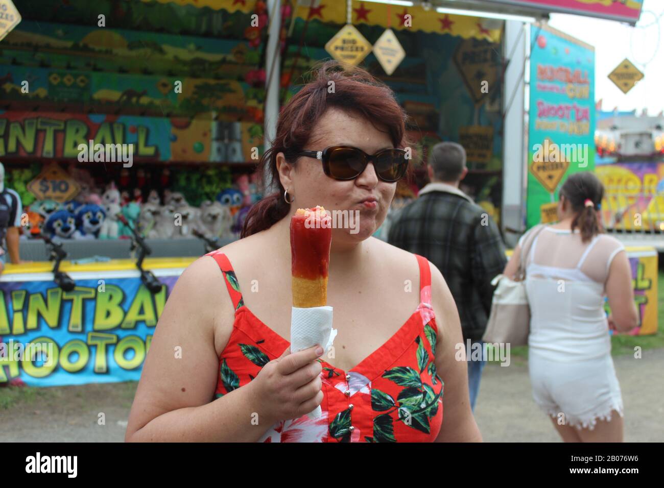Lady eating a tasty snack at the carnival Stock Photo - Alamy