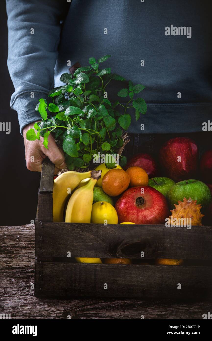 Organic fruit on wood. Farmer holding harvested fruit and vegetables ...
