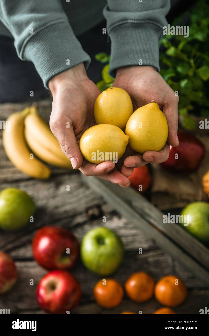 Organic fruit on wood. Farmer holding harvested fruit and vegetables ...