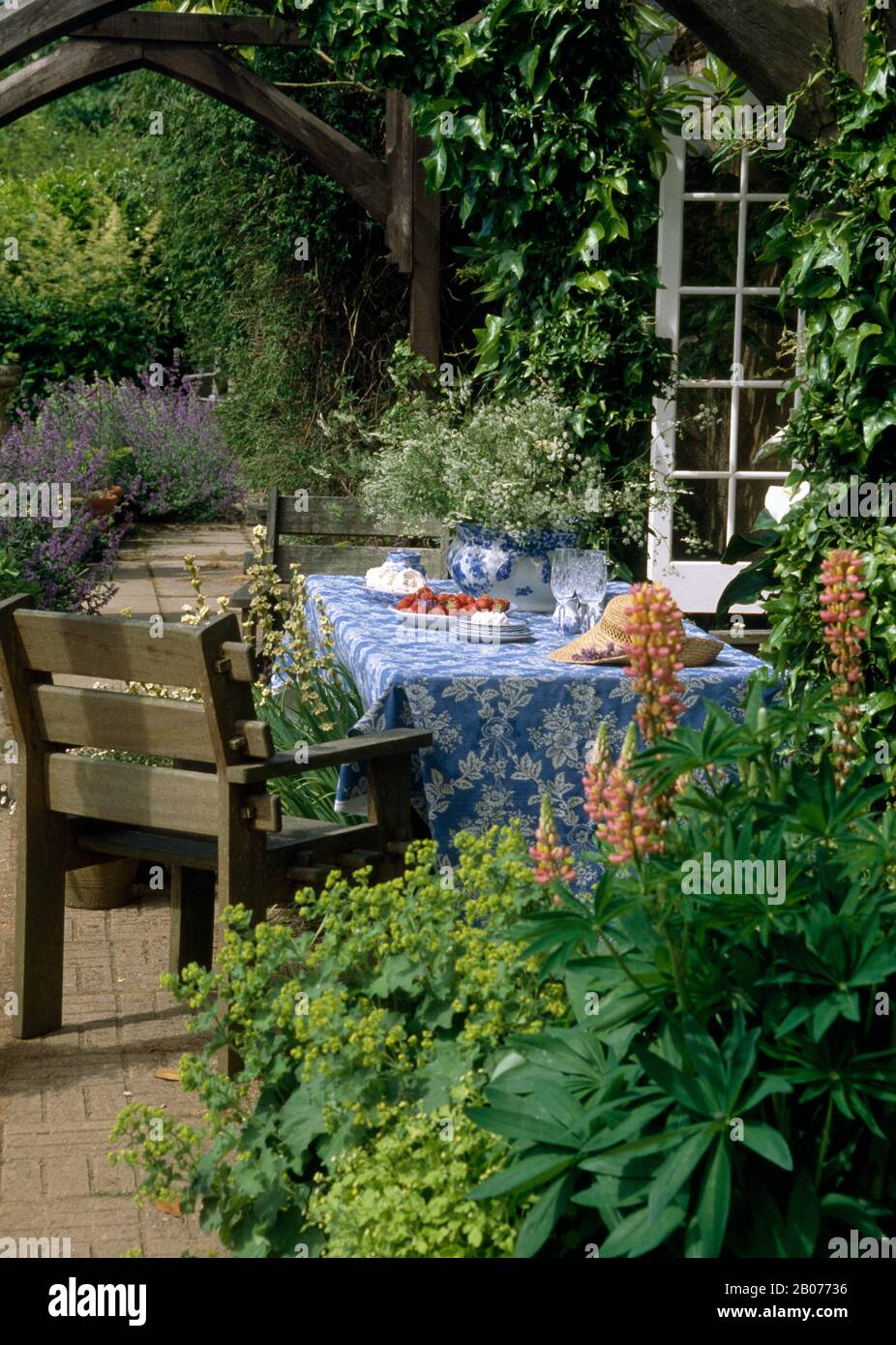 Blue table covered garden table for teatime Stock Photo - Alamy
