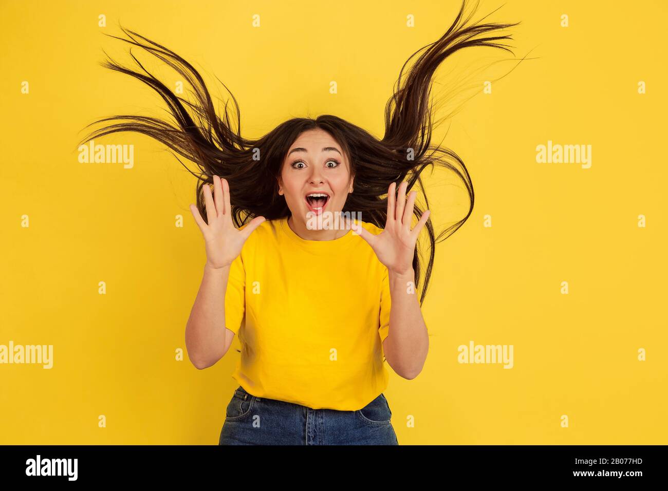 Astonished, wondered. Caucasian woman's portrait isolated on yellow ...