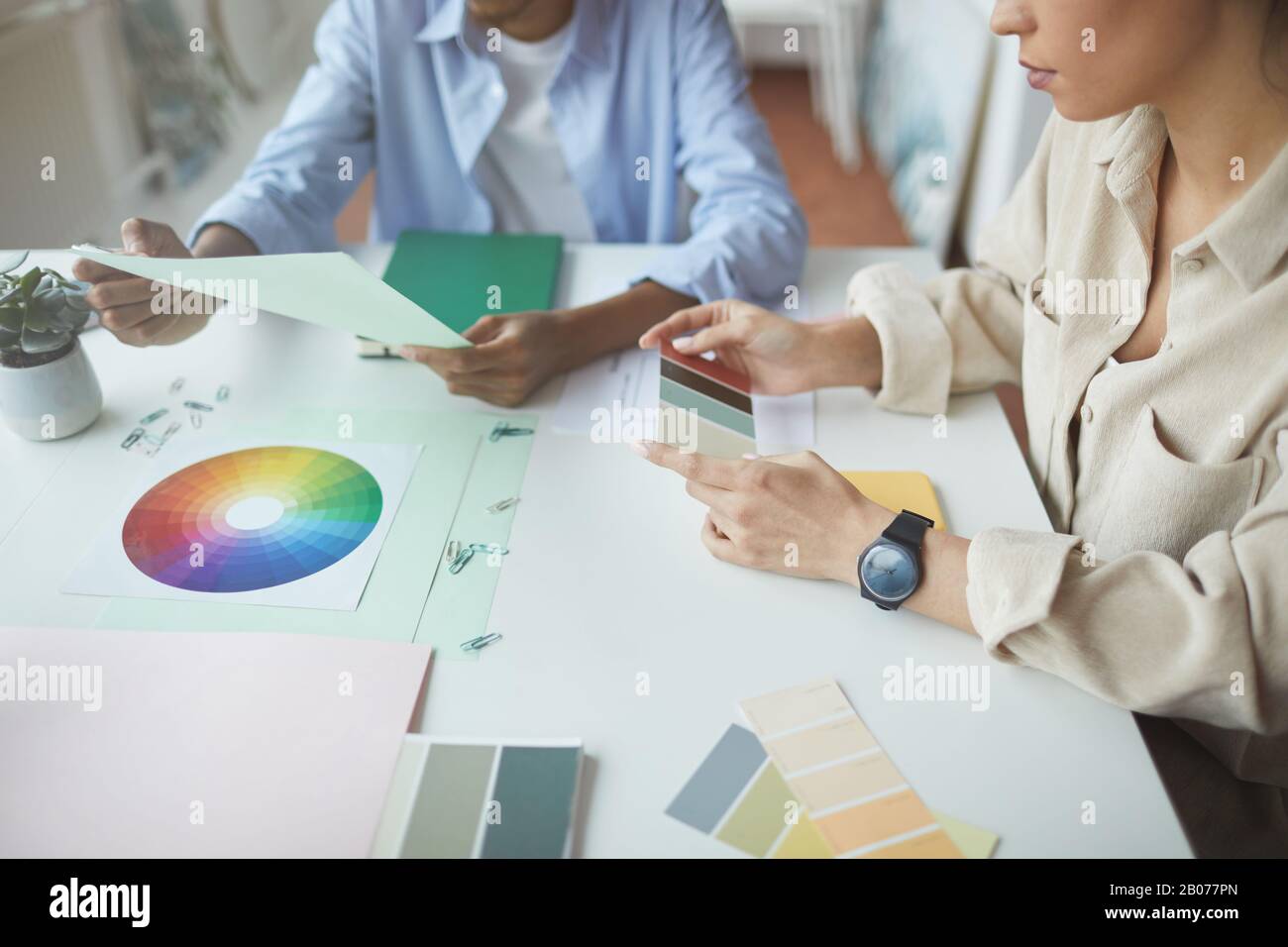 Close-up of group of designers sitting at the table and choosing the ...