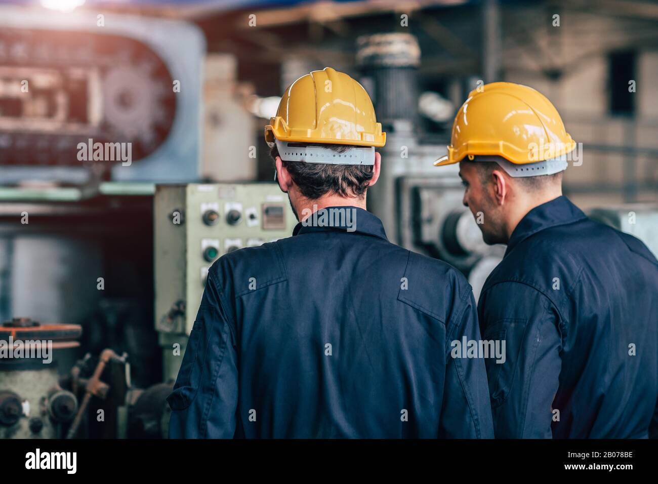 machine service talking together teamwork working in factory back view ...