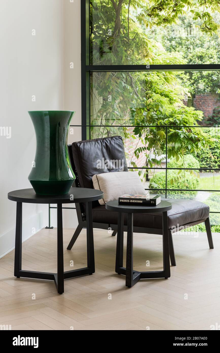 Leather chair and tables by window Stock Photo - Alamy