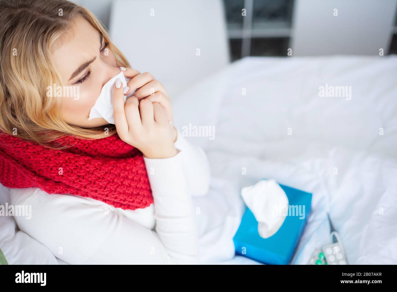 Sick Woman. Woman with flu virus lying in bed, she is measuring her ...