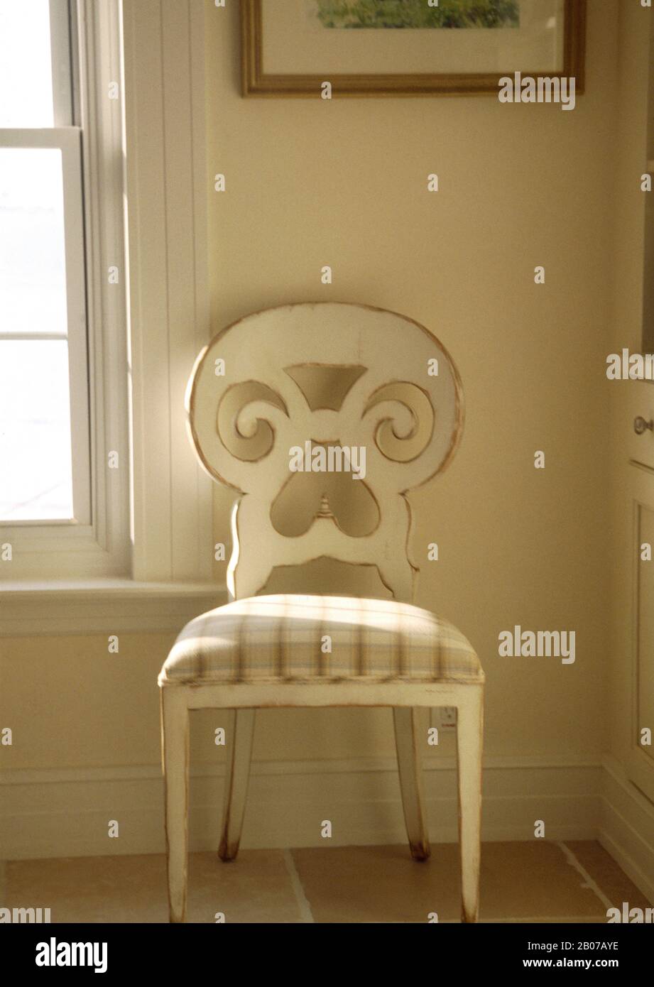 Single cream chair with check cushion on seat Stock Photo - Alamy
