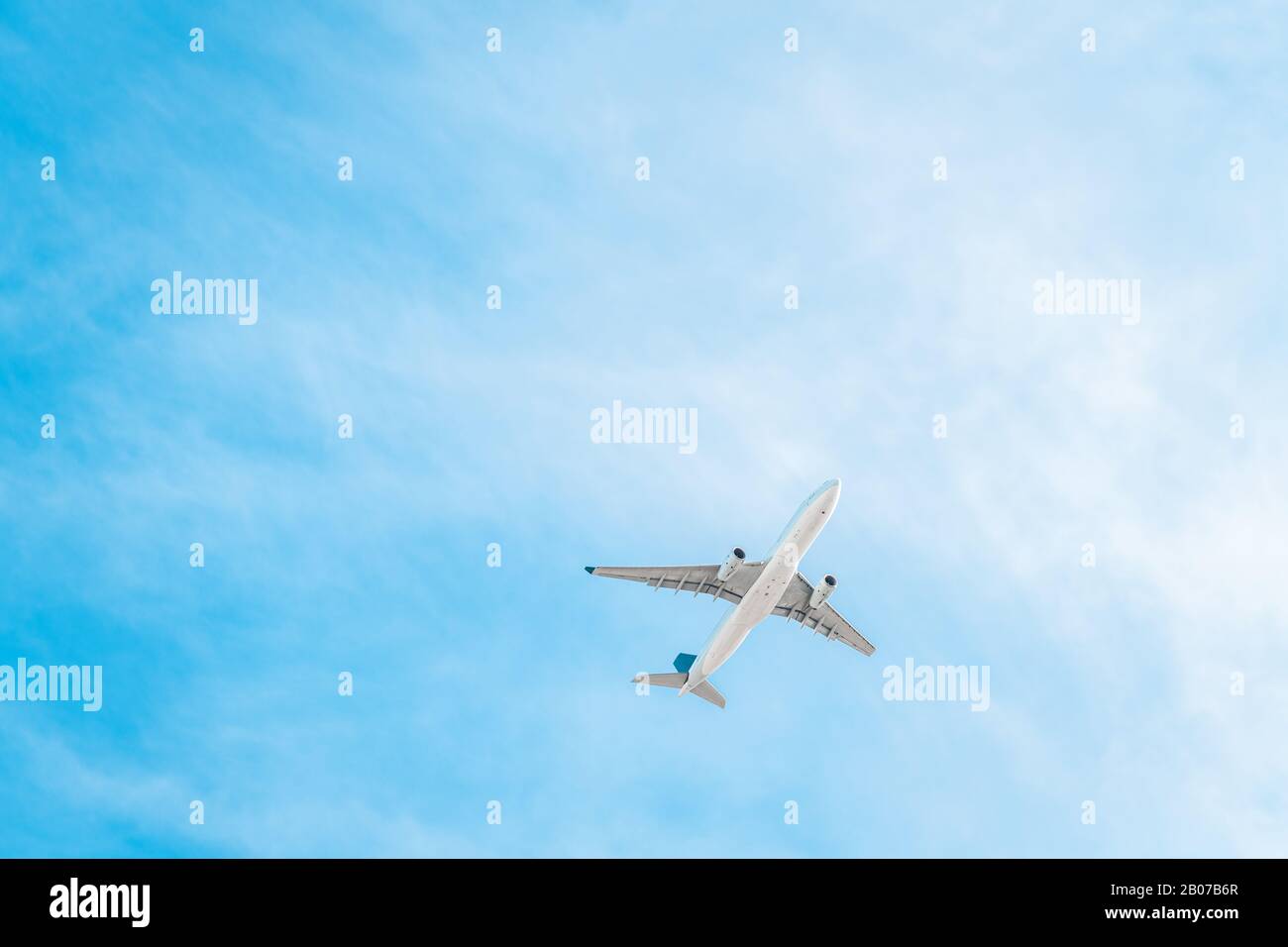 Large commercial passenger airplane flying under blue sky viewed from ...