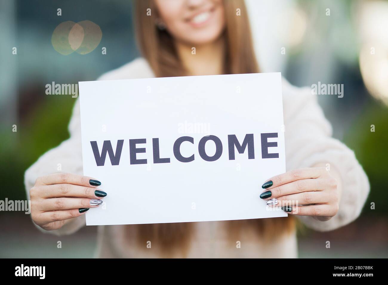 Women business with the poster with welcome message Stock Photo - Alamy