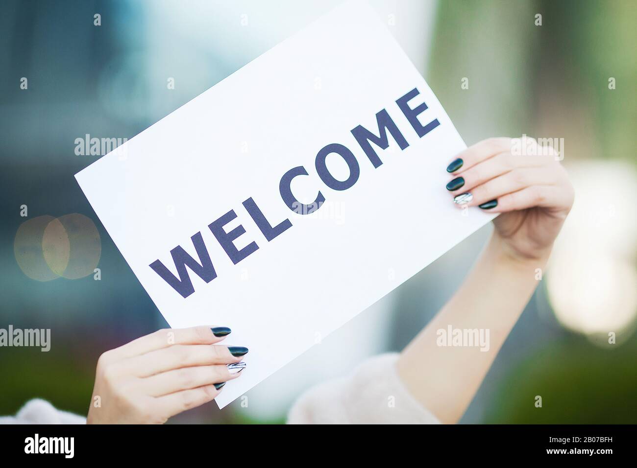 Women business with the poster with welcome message Stock Photo - Alamy