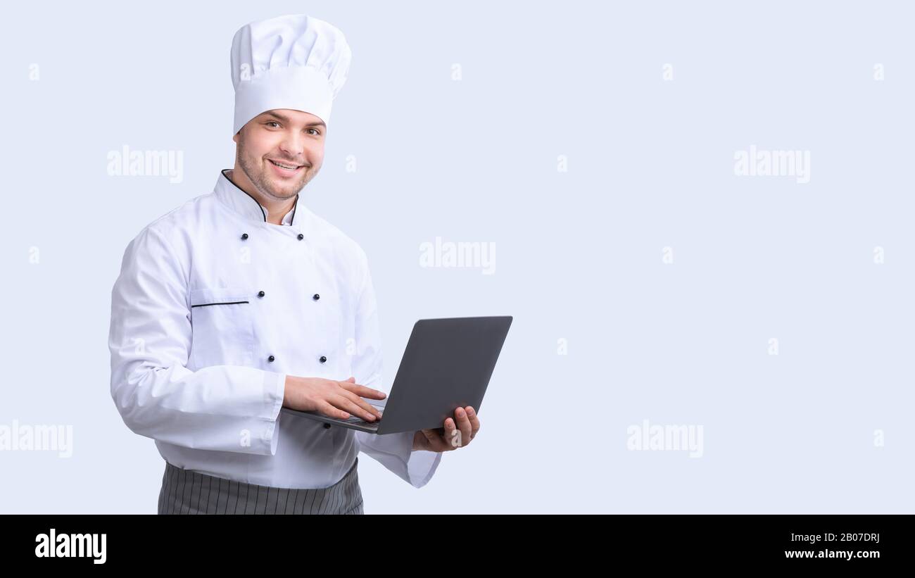 Cheerful Chef With Laptop Browsing Internet Standing In Studio ...