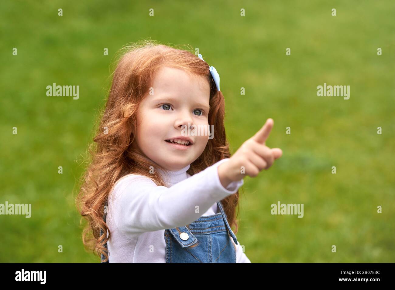 Beauty little woman portrait outdoor. Green background with copyspace ...