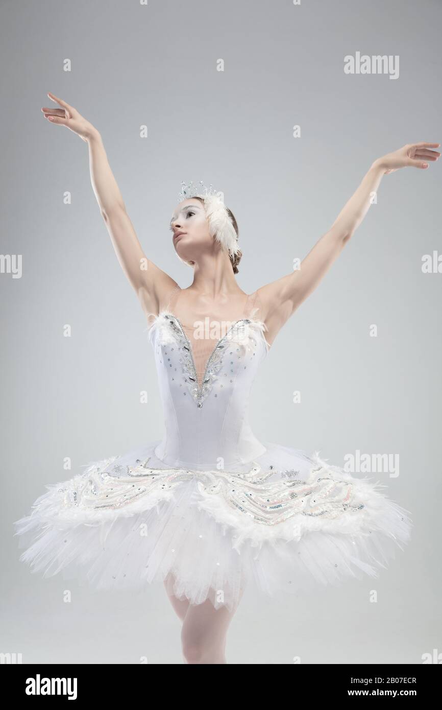 Close up of graceful classic ballerina dancing on white studio ...