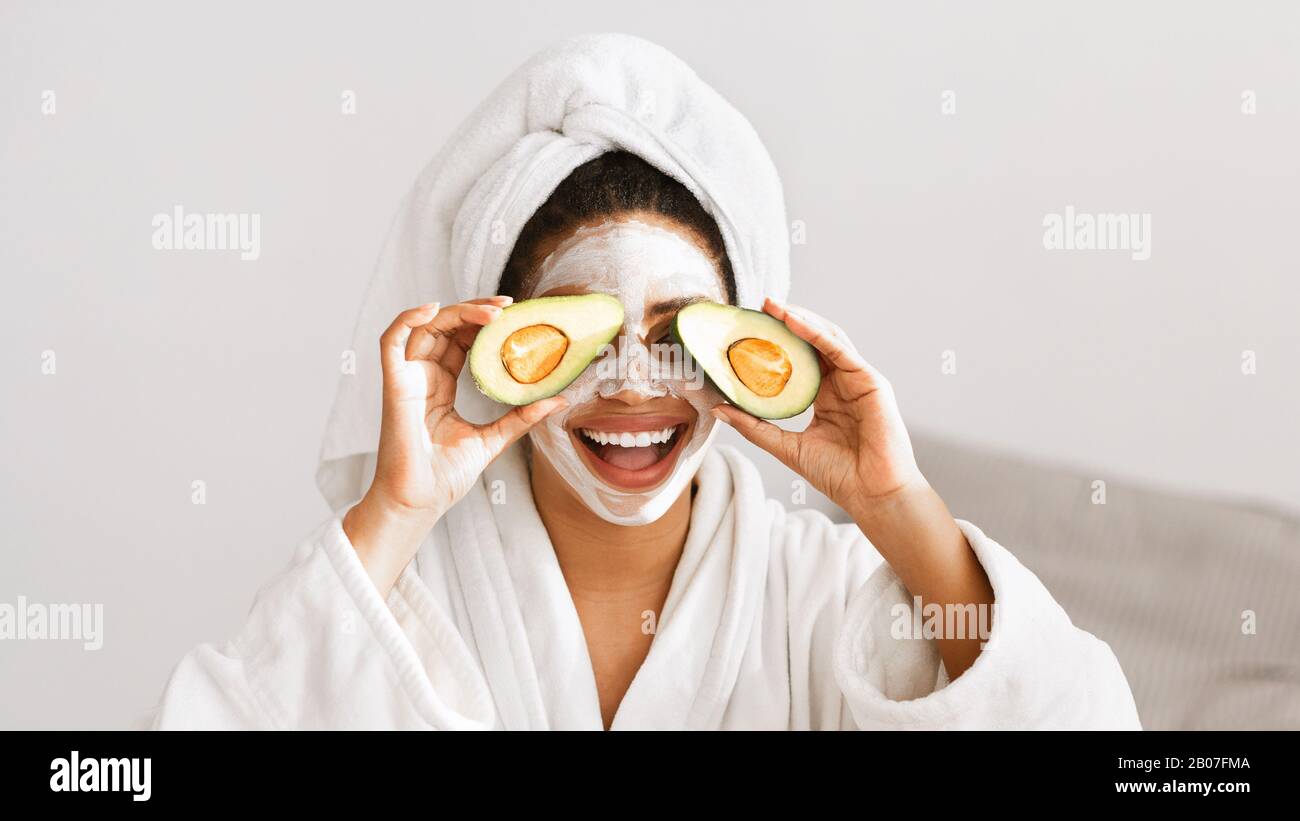 Afro girl with face mask on covering eyes with avocado Stock Photo - Alamy