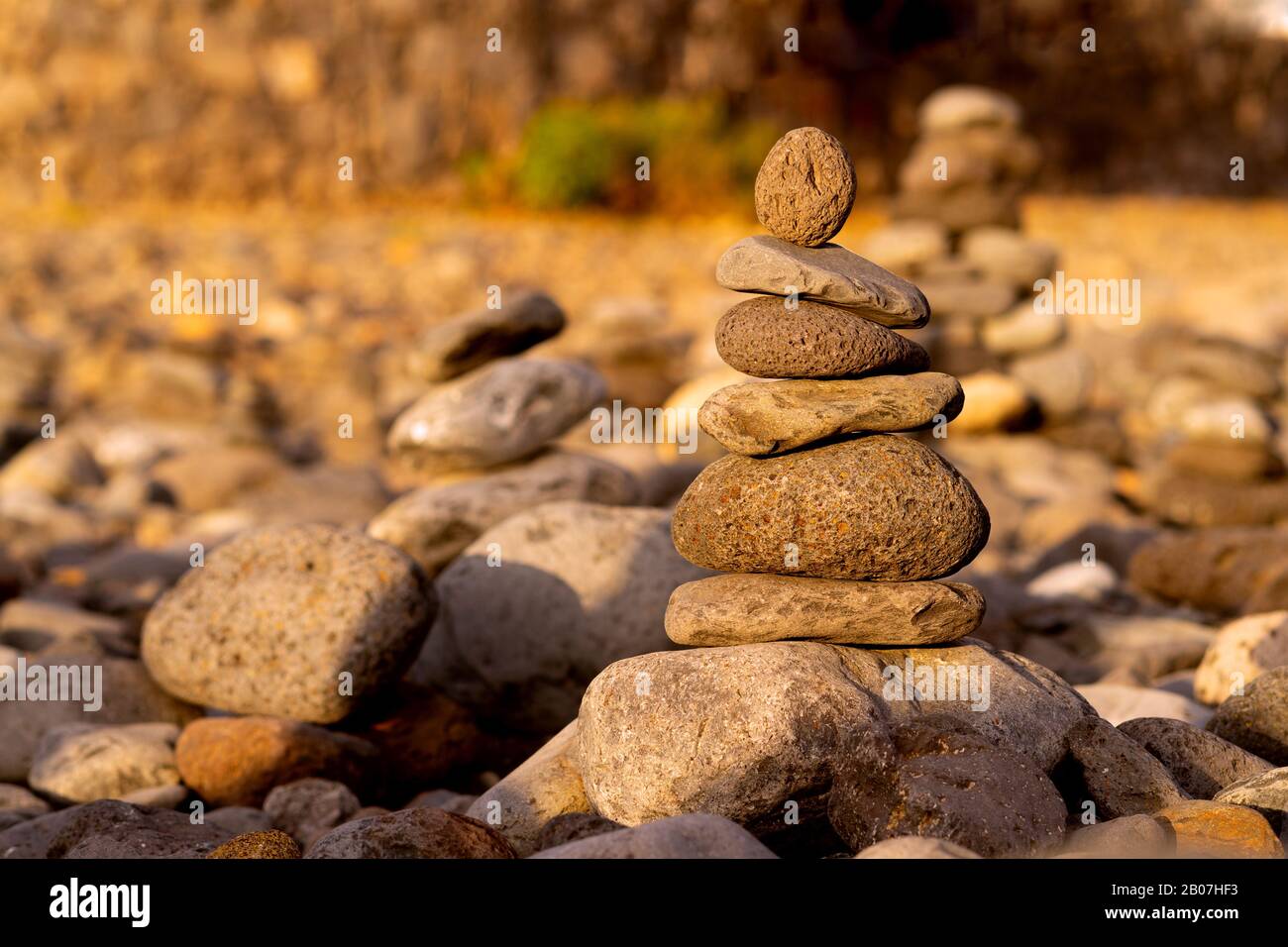 Balanced stone pyramide on shore of the ocean at dawn. Sea pebbles ...
