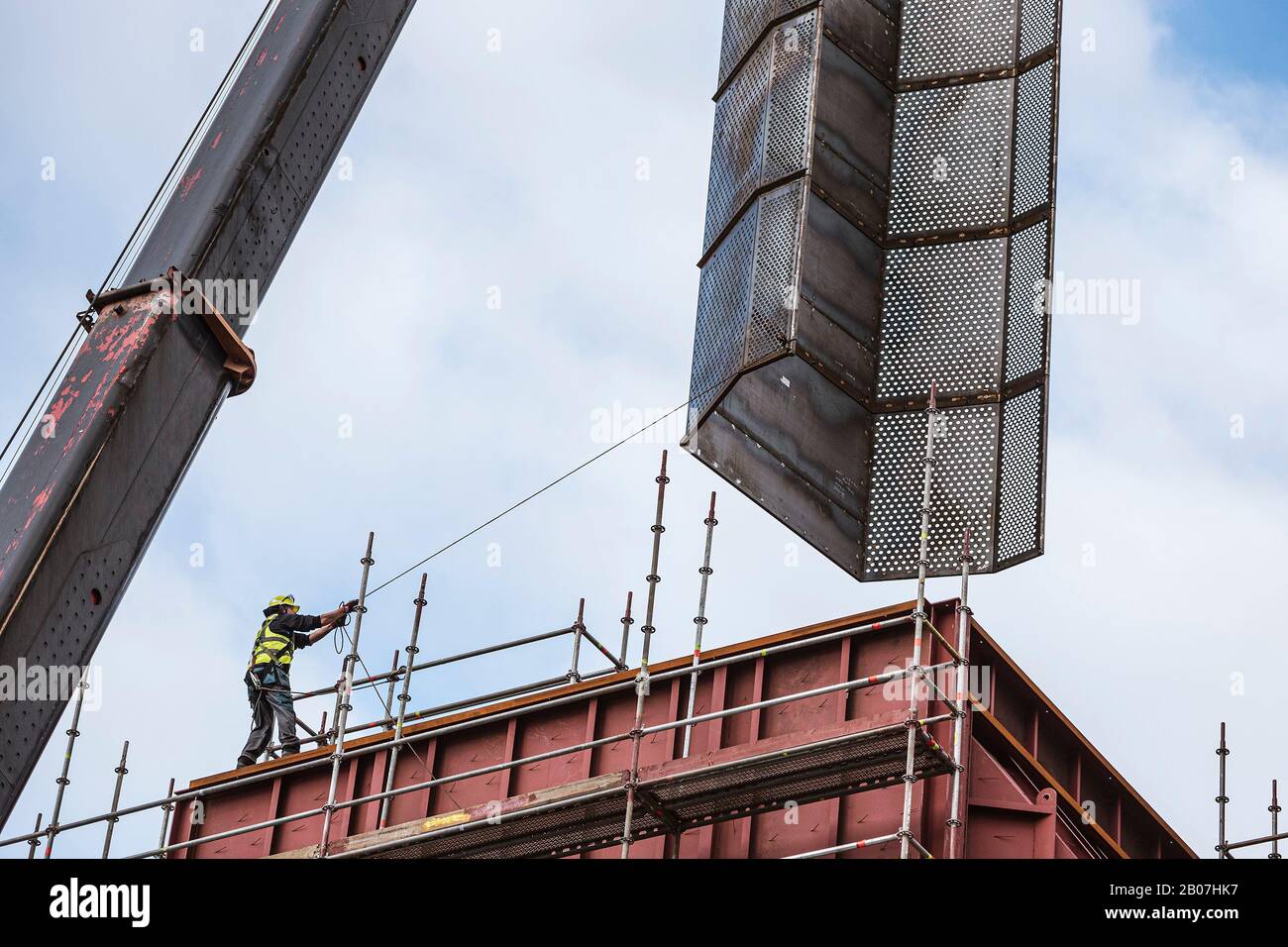 Blue color worker pulls a rope at height Stock Photo - Alamy