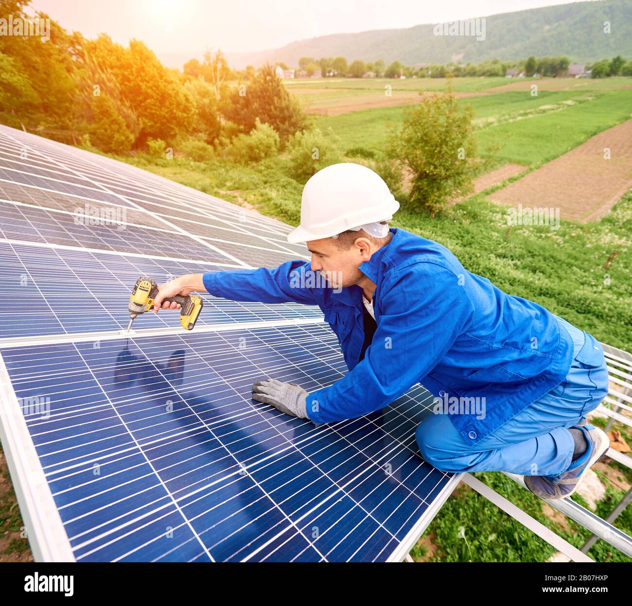 Construction worker connects photo voltaic panel to solar system using ...