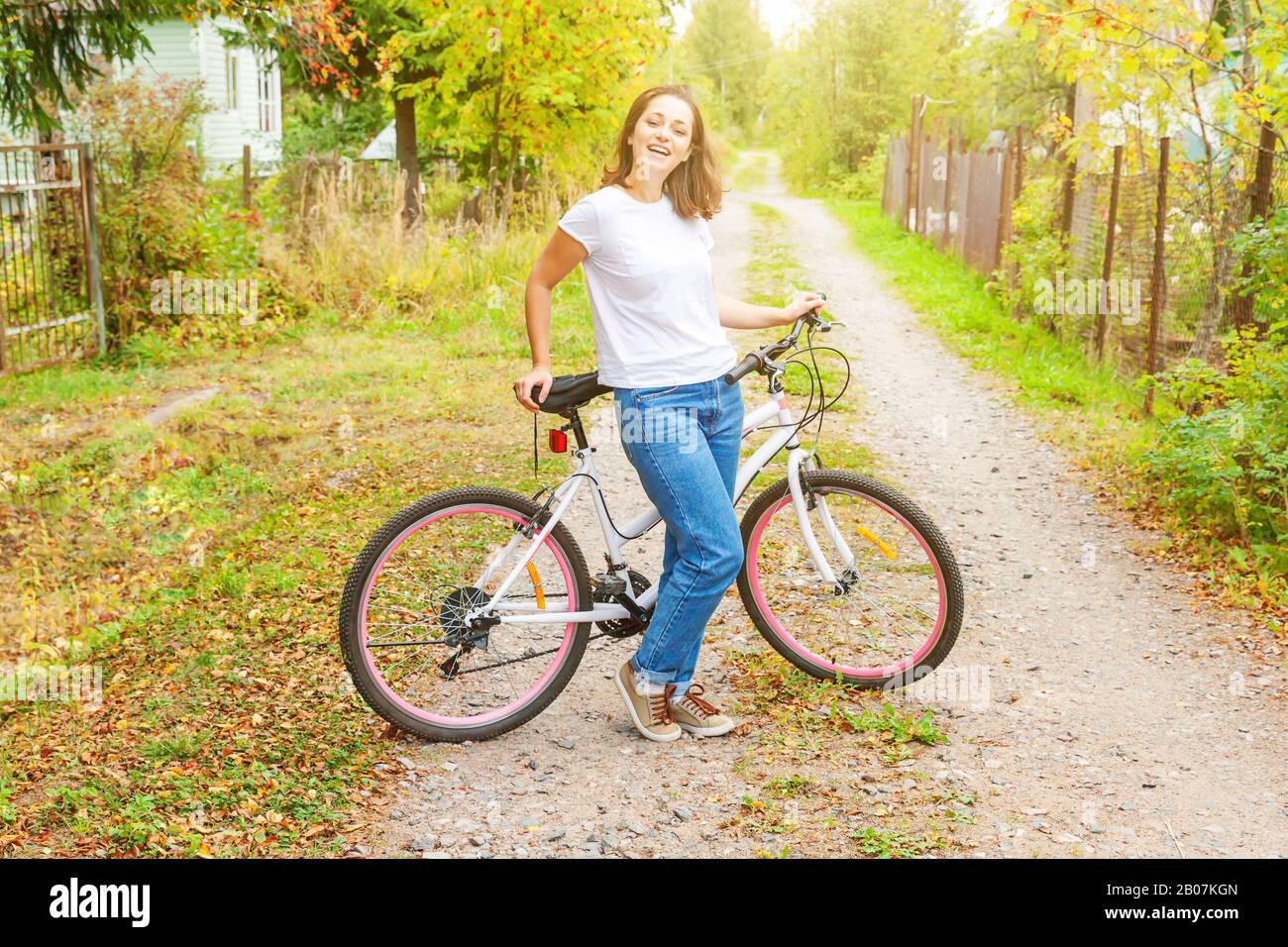 Young woman riding bicycle in summer city park outdoors. Active people ...