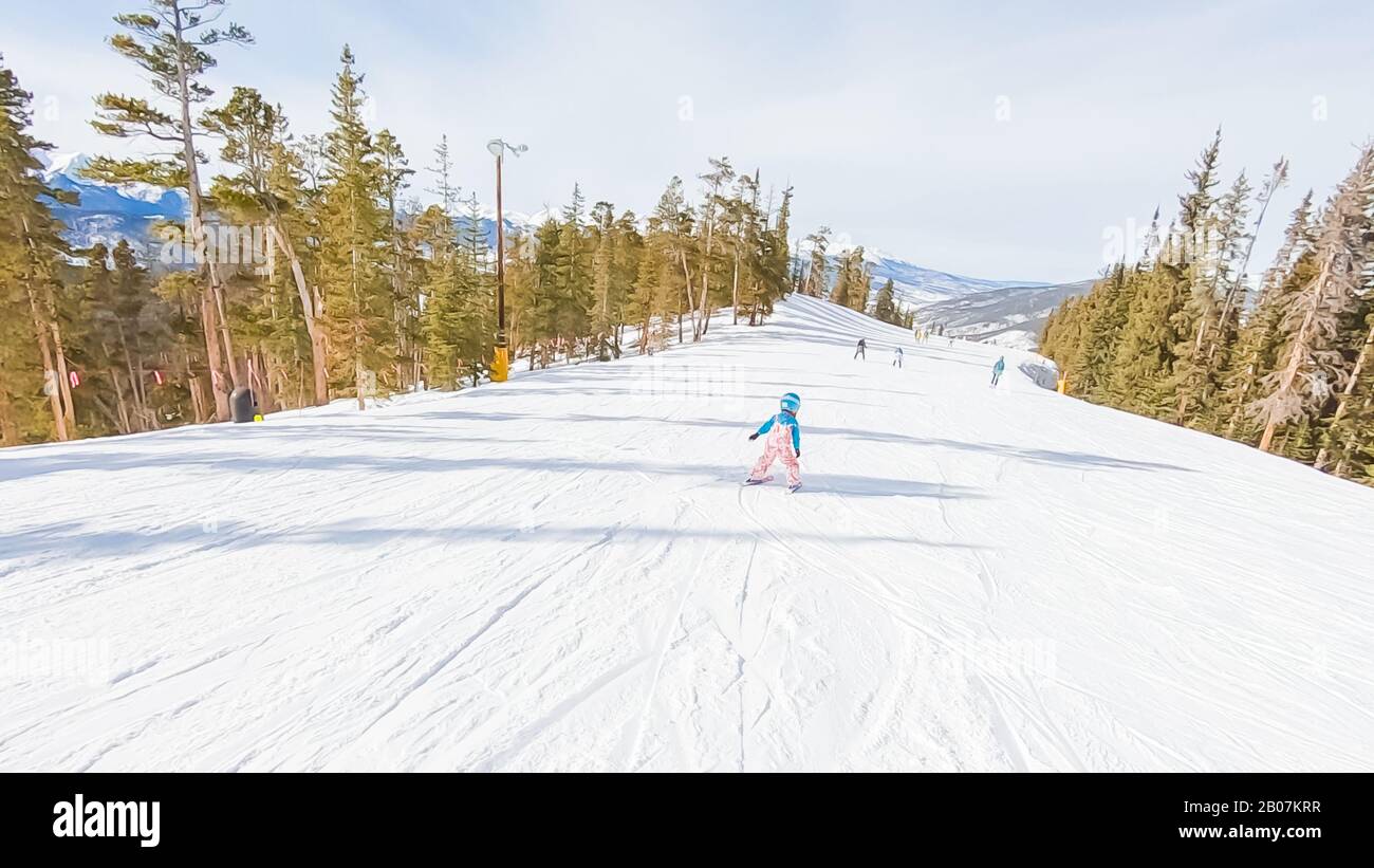 Little girl learning how to ski down the hill on alpine mountains Stock ...