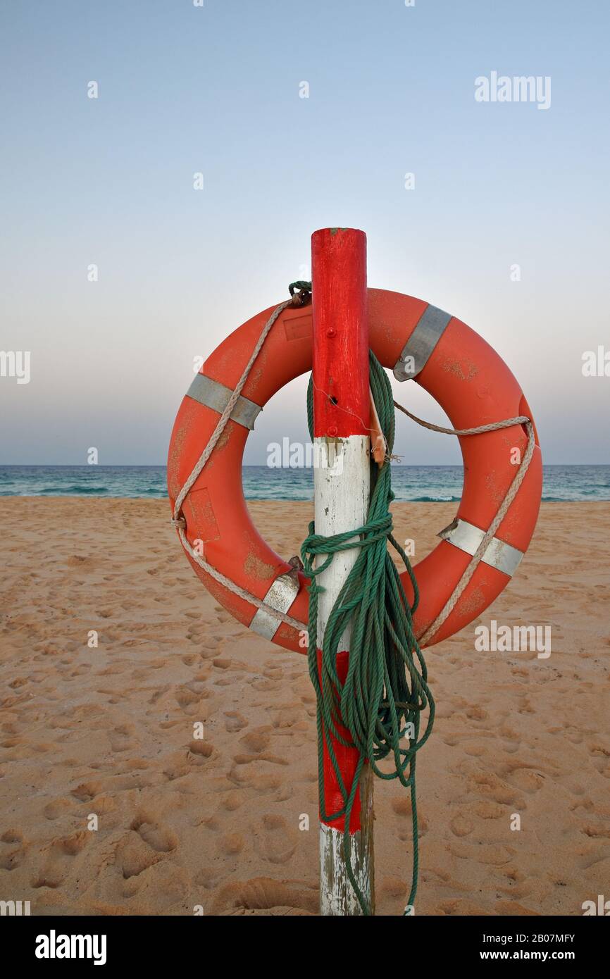 Orange life saver ring on wooden post with green rope on Corralejo ...