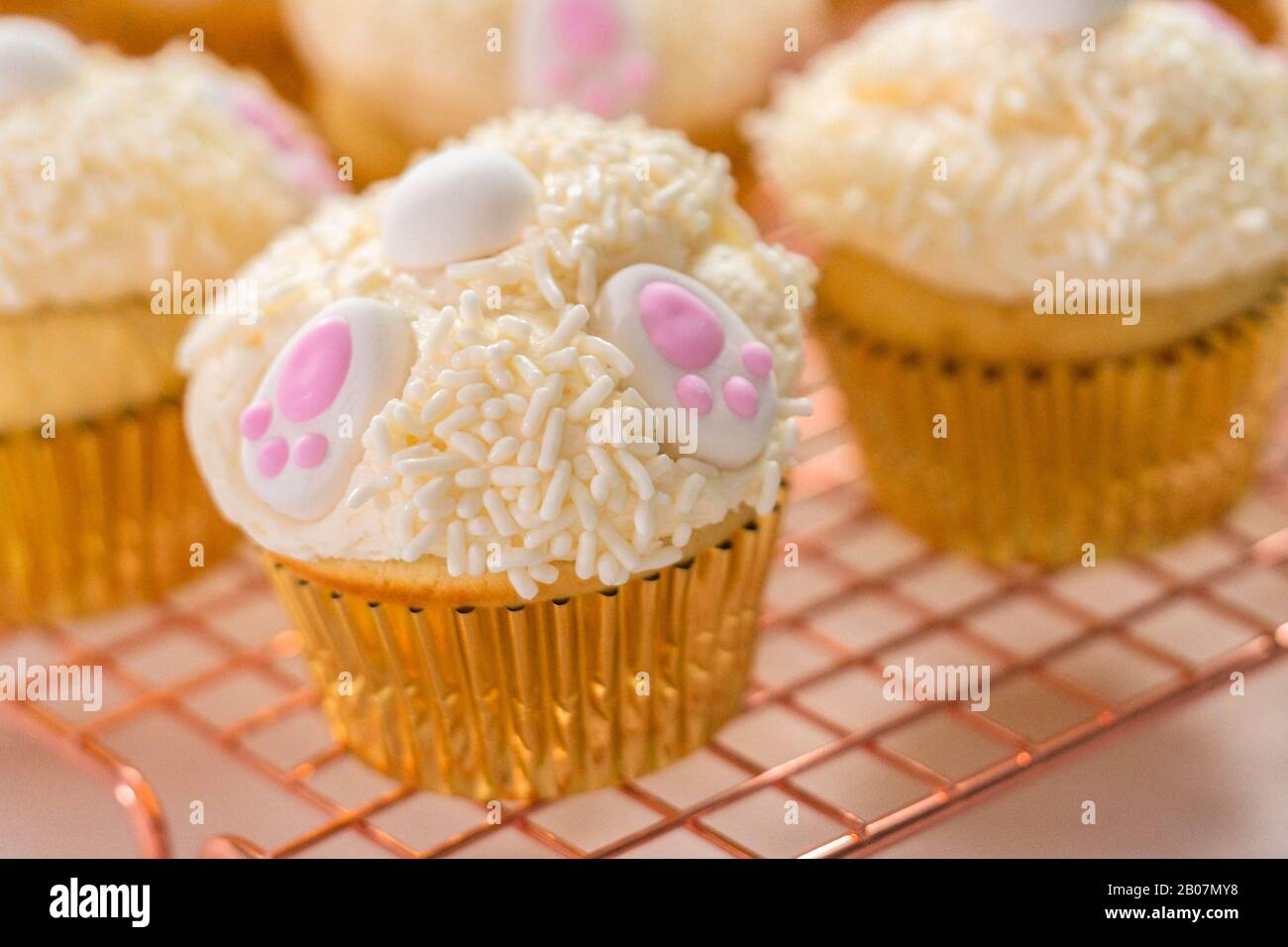 Decorating vanilla cupcakes with a white buttercream icing and bunny ...