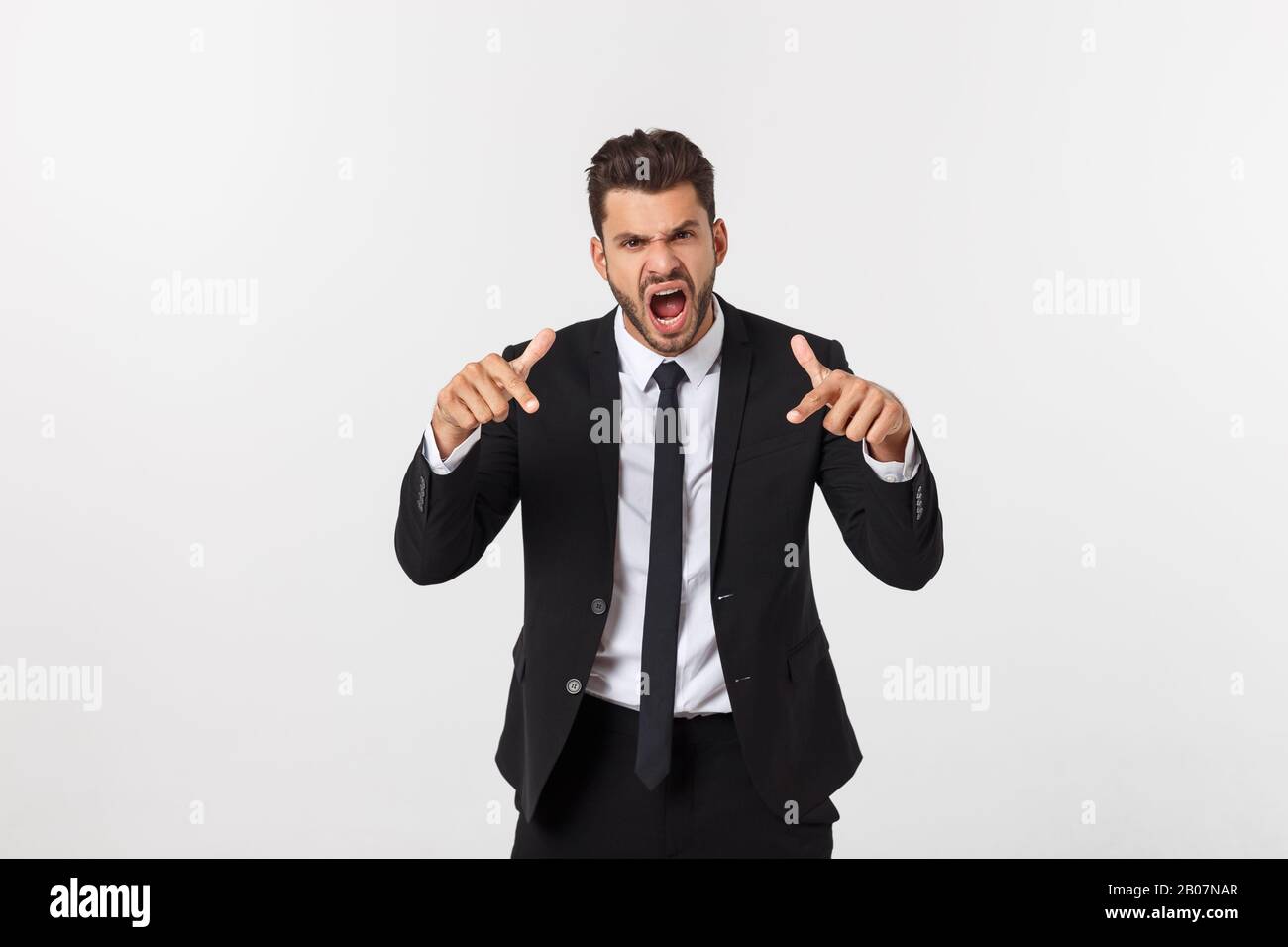 young handsome man shouting aggressively, looking very angry ...