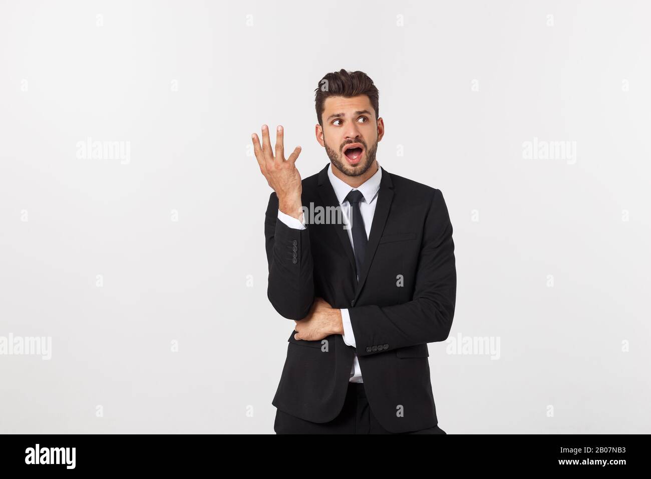 young handsome man shouting aggressively, looking very angry ...