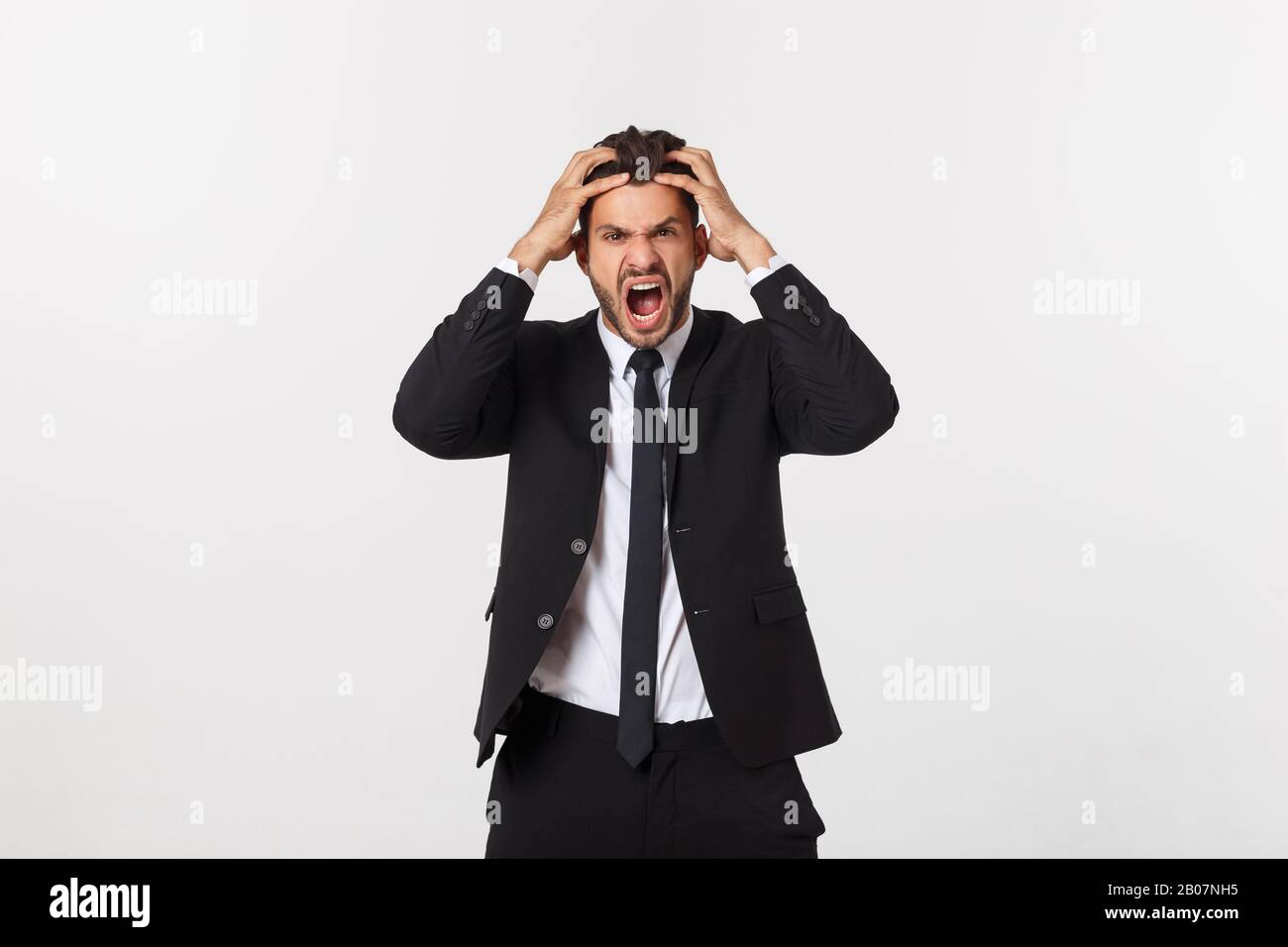 young handsome man shouting aggressively, looking very angry ...