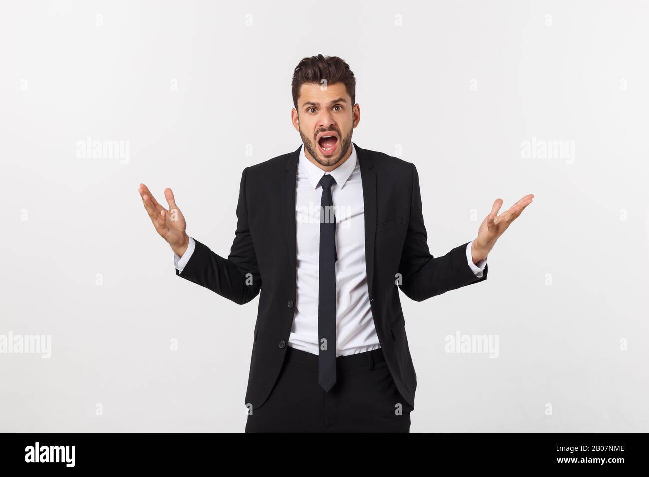 young handsome man shouting aggressively, looking very angry ...