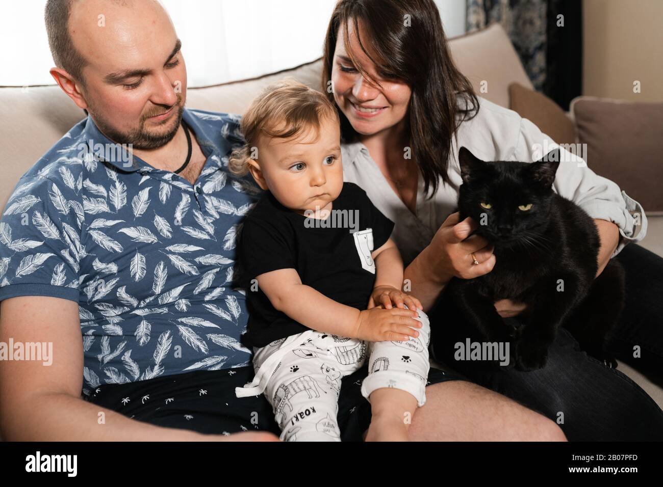 Family values: Mother and father playing with baby child boy indoor - Parents wearing blue and ...