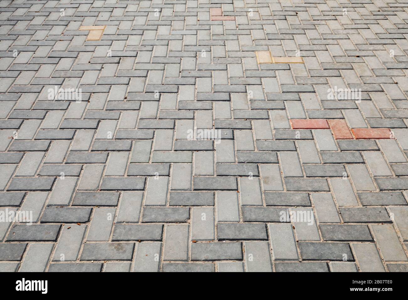 Gray cobblestone road pavement with colorful blocks, background photo ...