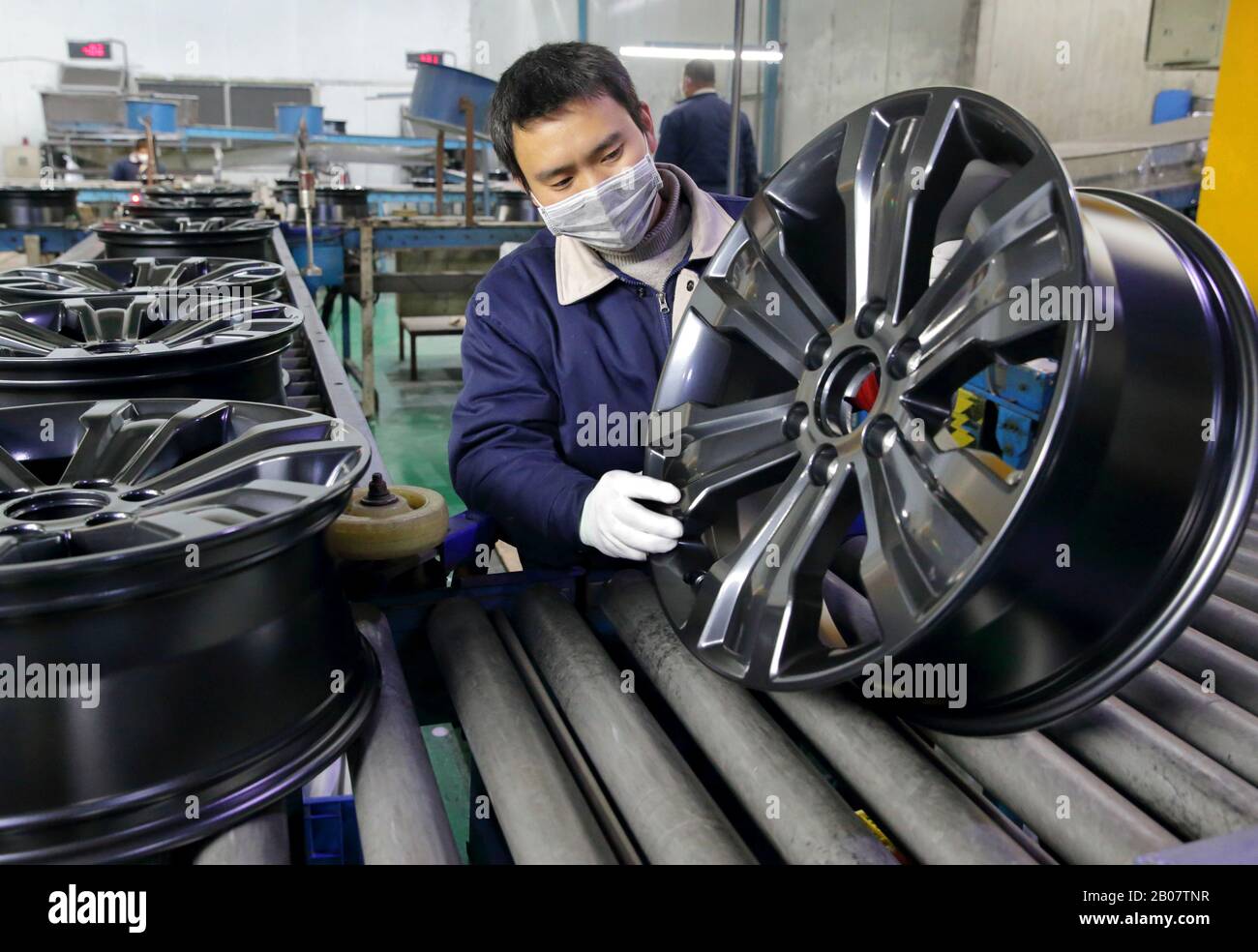 Chinese workers manufacture aluminium-alloy car rims at the plant of ...