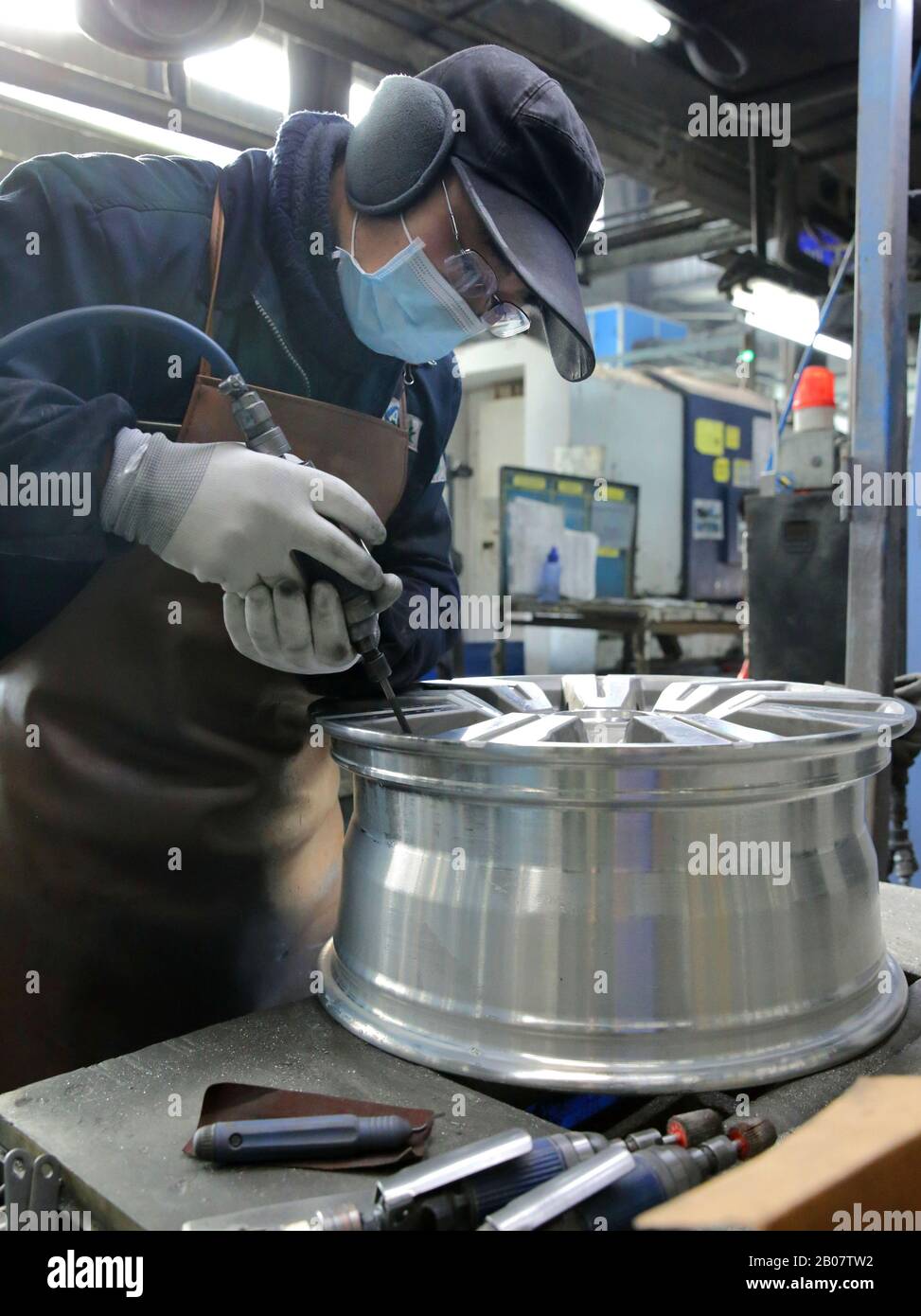 Chinese workers manufacture aluminium-alloy car rims at the plant of ...