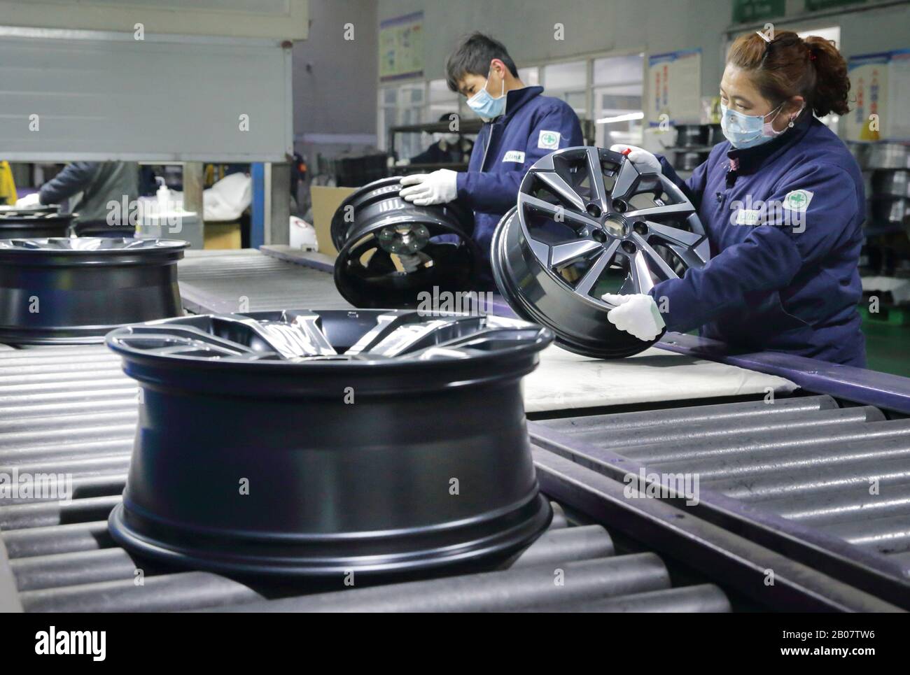 Chinese workers manufacture aluminium-alloy car rims at the plant of ...