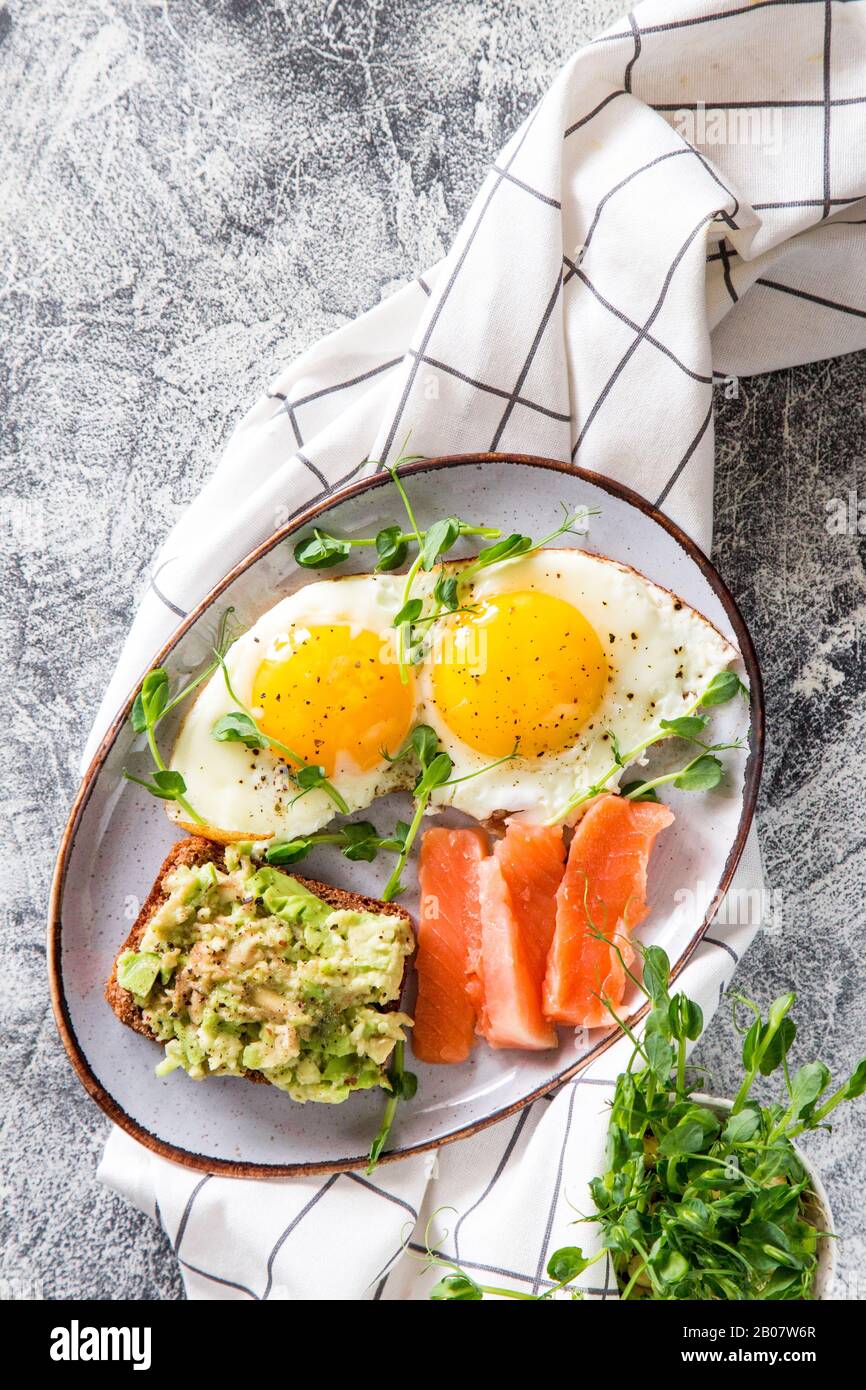 Egg breakfast. Healthy nutritious breakfast with eggs, salmon, avocado ...