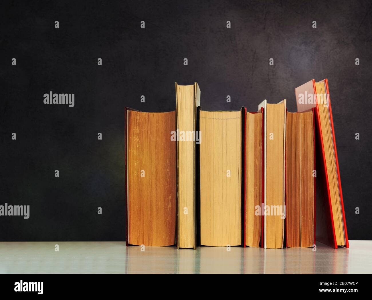 Back to school, pile of books with empty black school board background ...