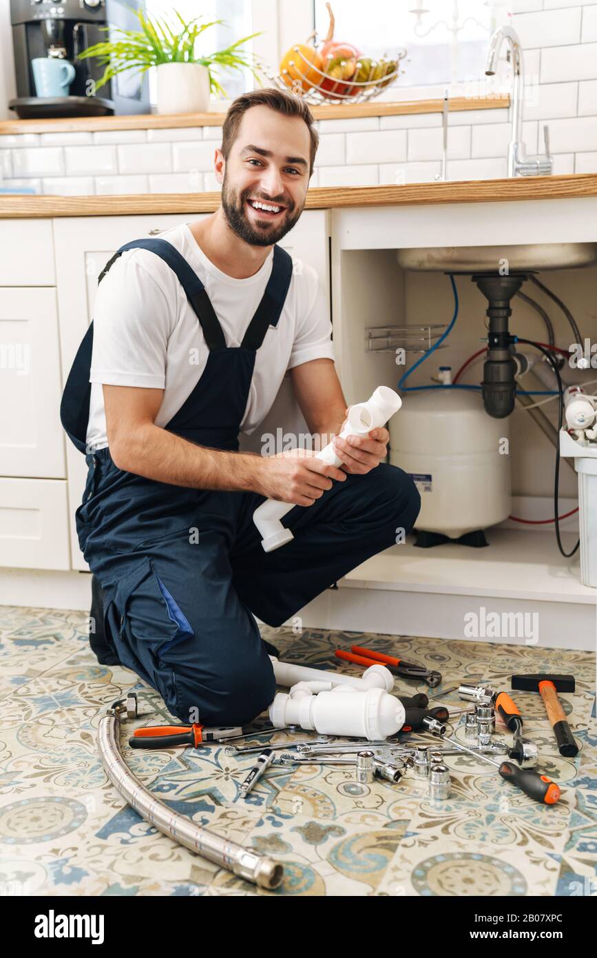 Handsome smiling plumber at the kitchen hi-res stock photography and ...