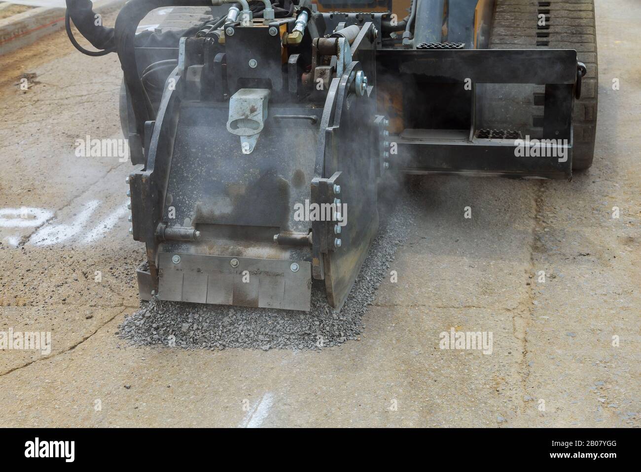 Road repair work milling machine removing old asphalt from the road ...