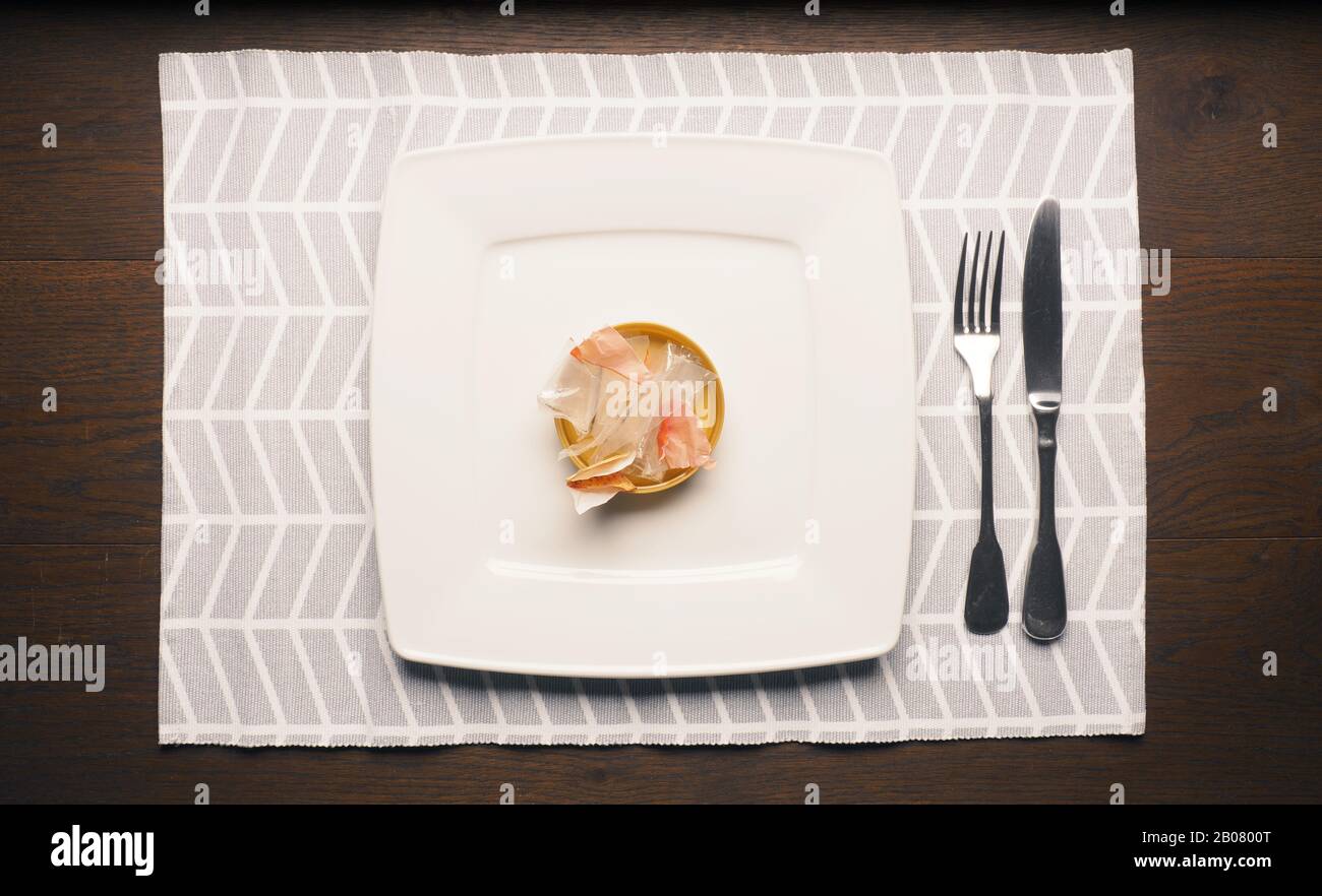plastic garbage on a plate with cutlery on a wooden table, packaging ...