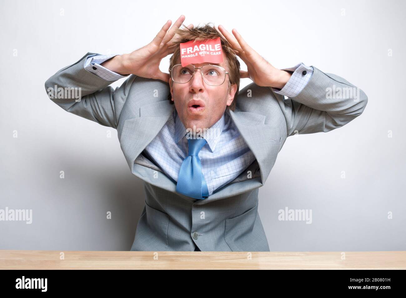 Worried office worker with a Fragile Handle With Care sticker sitting ...