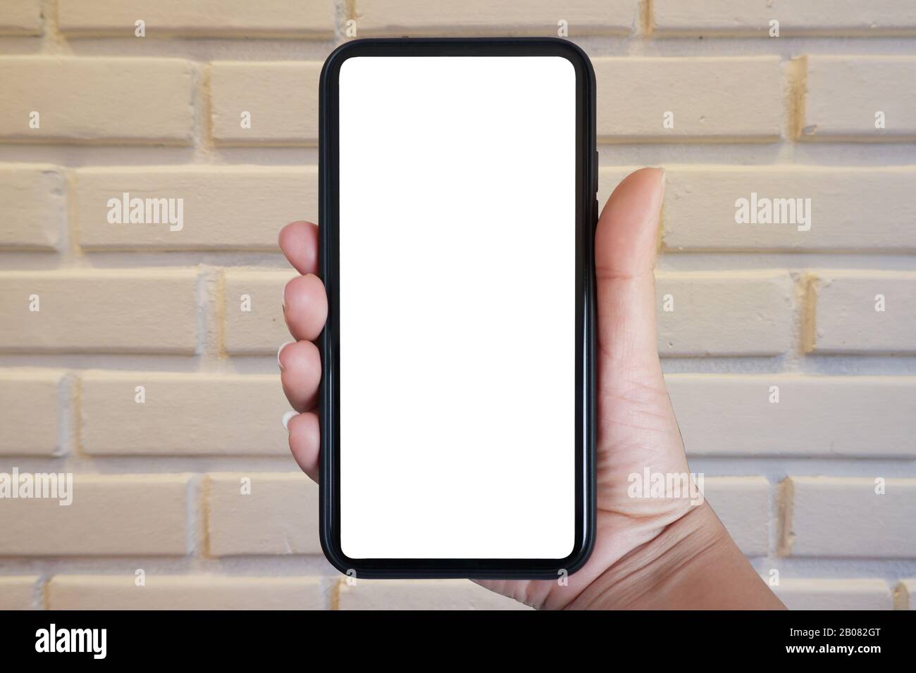 Close-up hand holding phone vertical, Using smart phone towards white ...