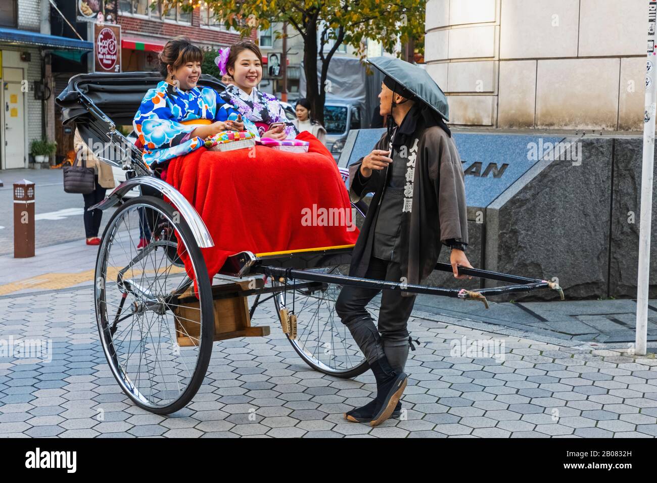 Japan, Honshu, Tokyo, Asakusa, Two Young Women Dressed in Kimono Riding ...