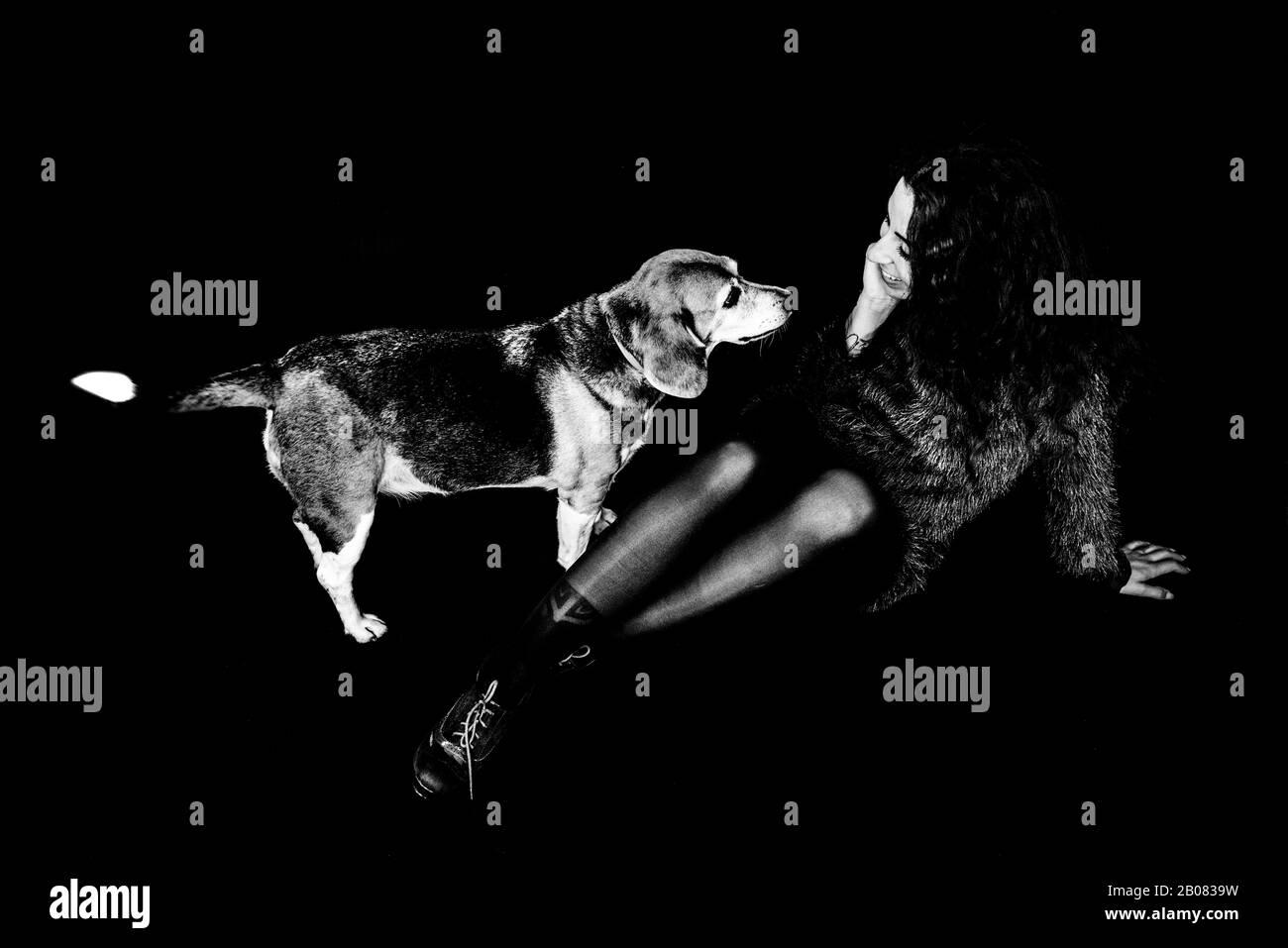 high contrast black and white image of smiling girl with her beagle dog ...