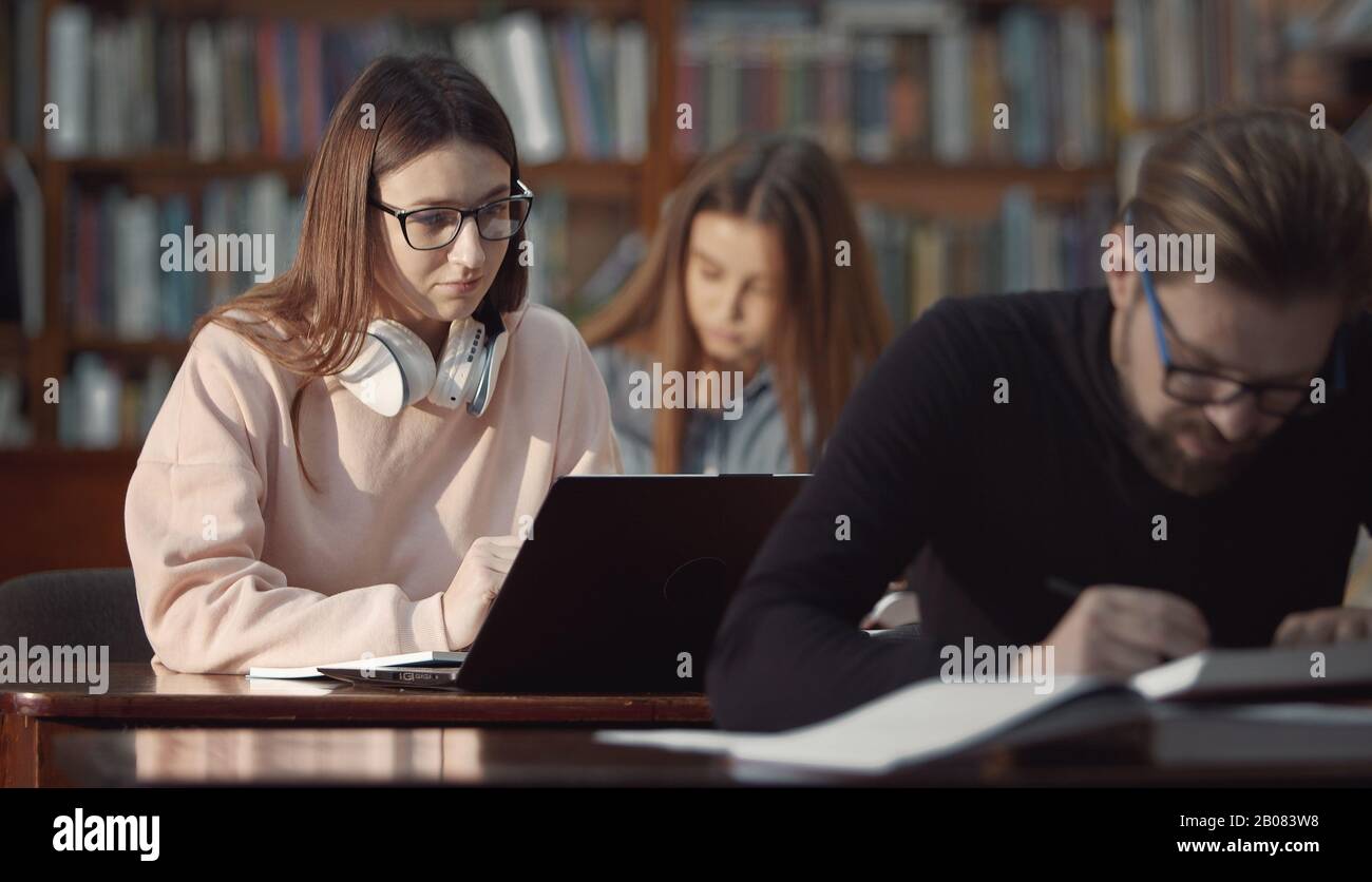 Student working laptop in library Stock Photo - Alamy