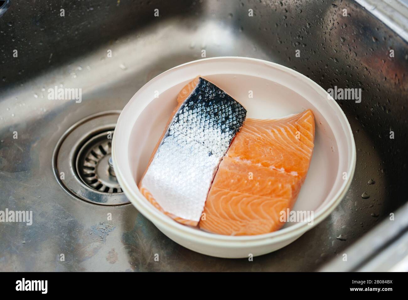 Kitchen stainless steel sink with plastic bowl containing two pieces of ...