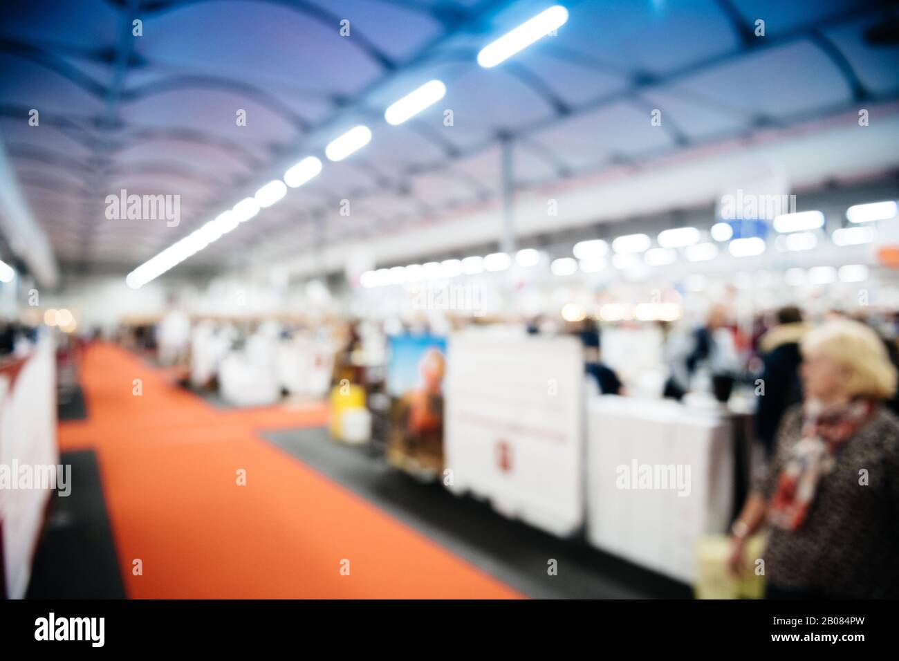 Defocused view of large hall with silhouettes of people visiting the ...