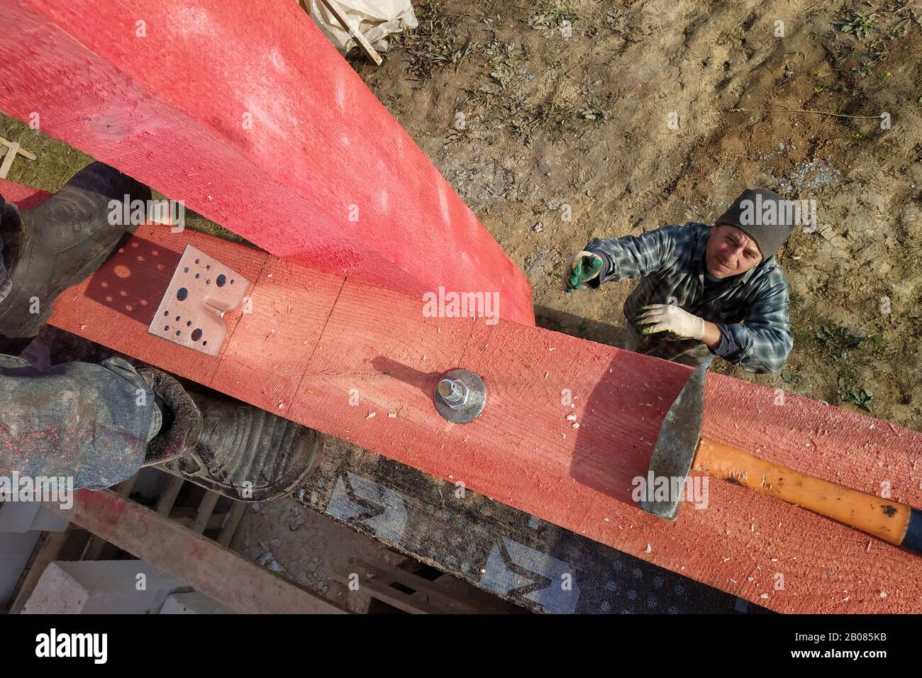 In the roof rafters the worker screws the screws into the screwdriver ...