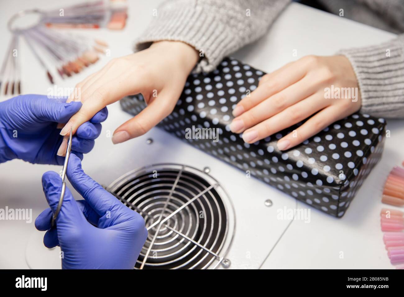 Manicurist cut cuticle scissors tool on nails of client girl, top view ...