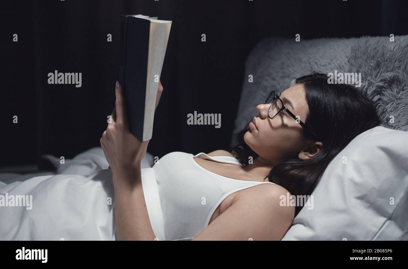 Female reading book before bed Stock Photo - Alamy