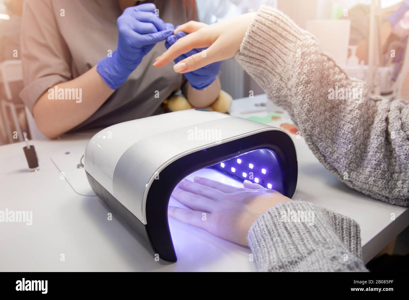 Manicure master applies pink color hi-res stock photography and images ...